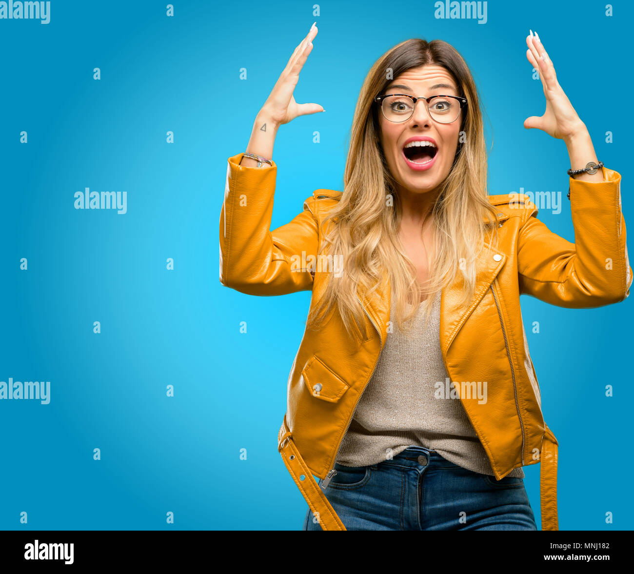 Beautiful young woman happy and surprised cheering expressing wow ...
