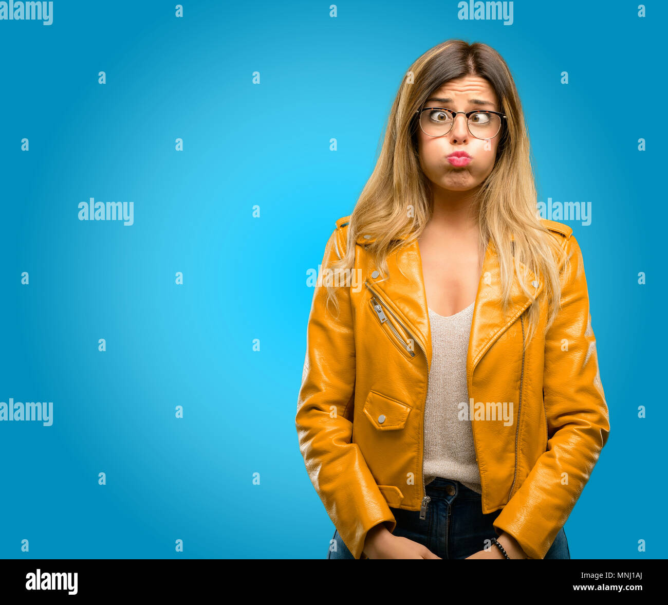 Beautiful young woman puffing out cheeks, having fun making funny face ...