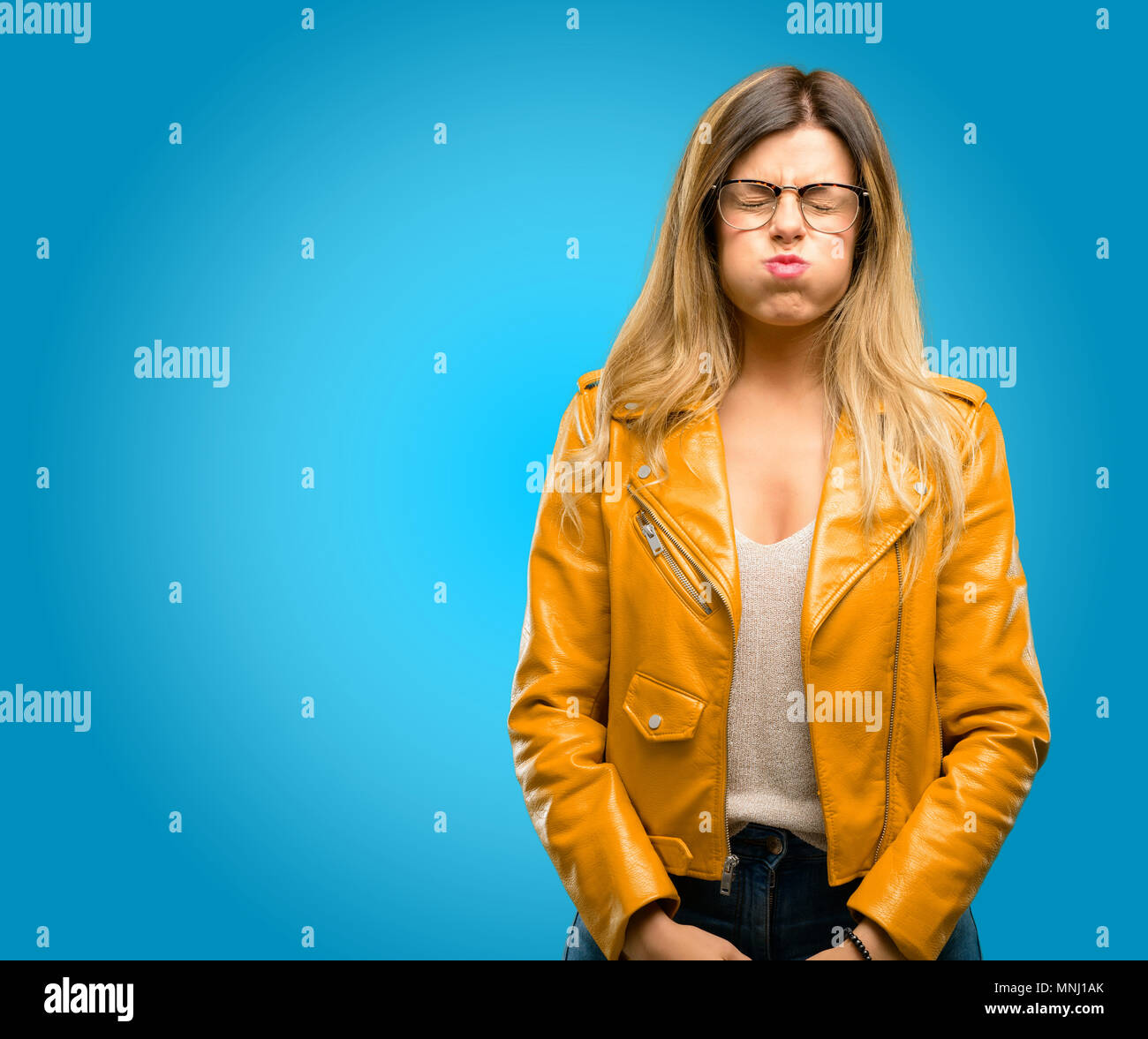 Beautiful young woman puffing out cheeks, having fun making funny face ...