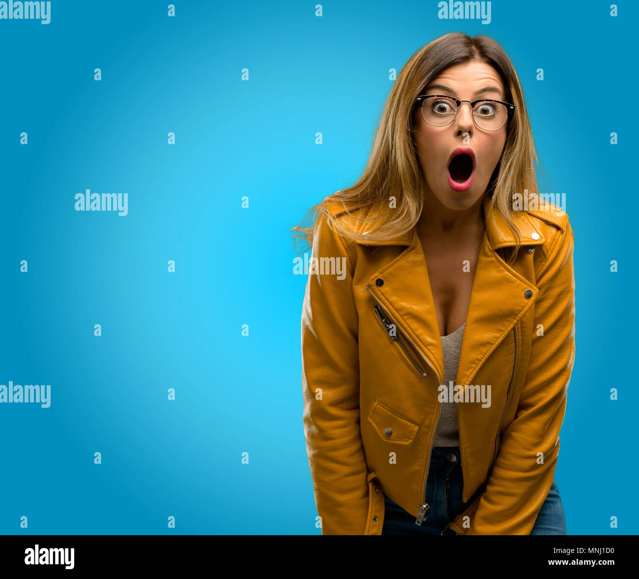 Beautiful young woman scared and surprised cheering expressing wow ...