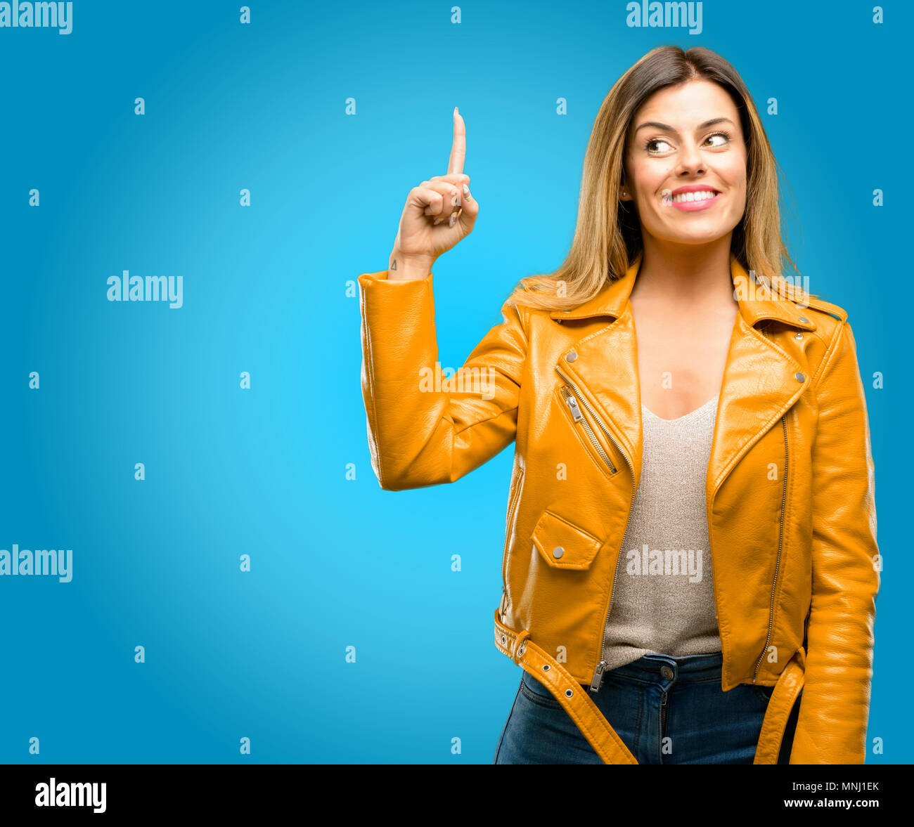 Beautiful young woman raising his finger, is the number one, blue ...