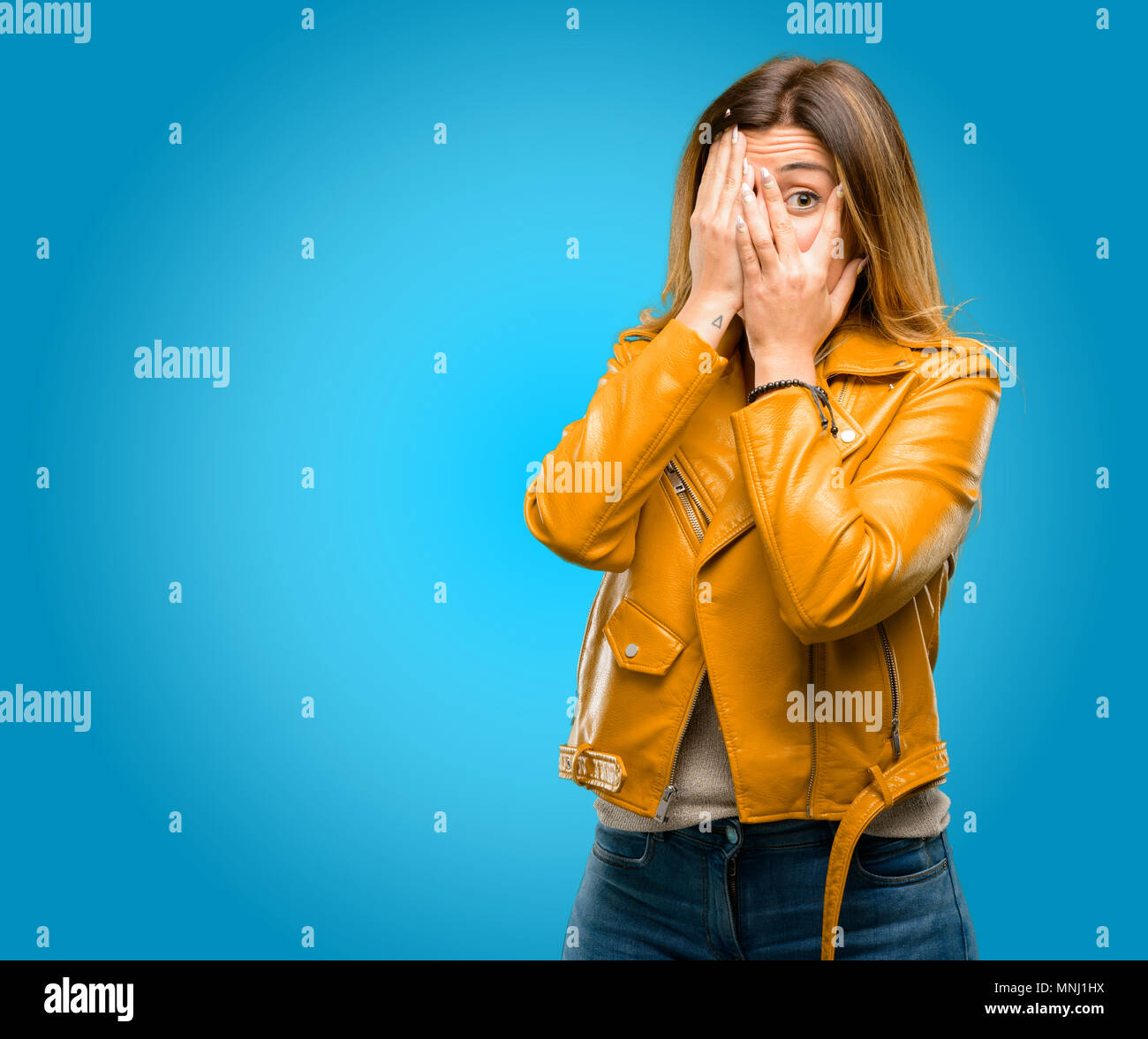 Beautiful young woman smiling having shy look peeking through her ...