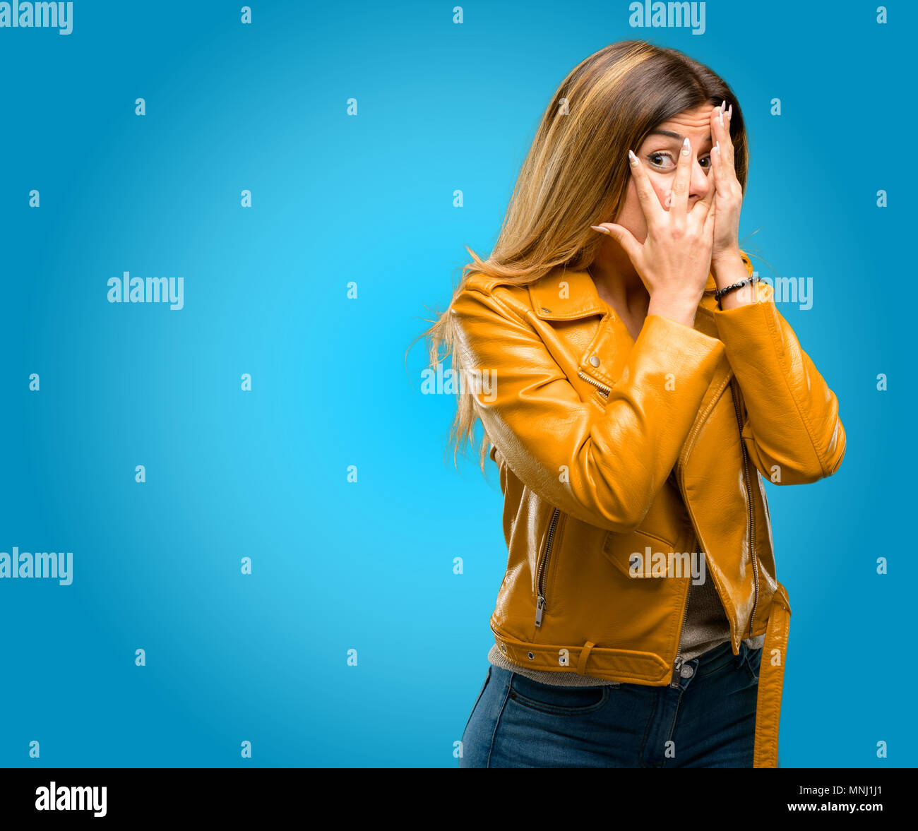 Beautiful young woman smiling having shy look peeking through her ...