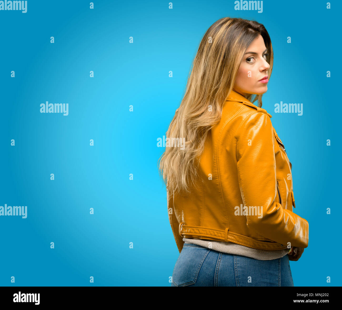 Beautiful young woman backside, rear view, blue background Stock Photo ...