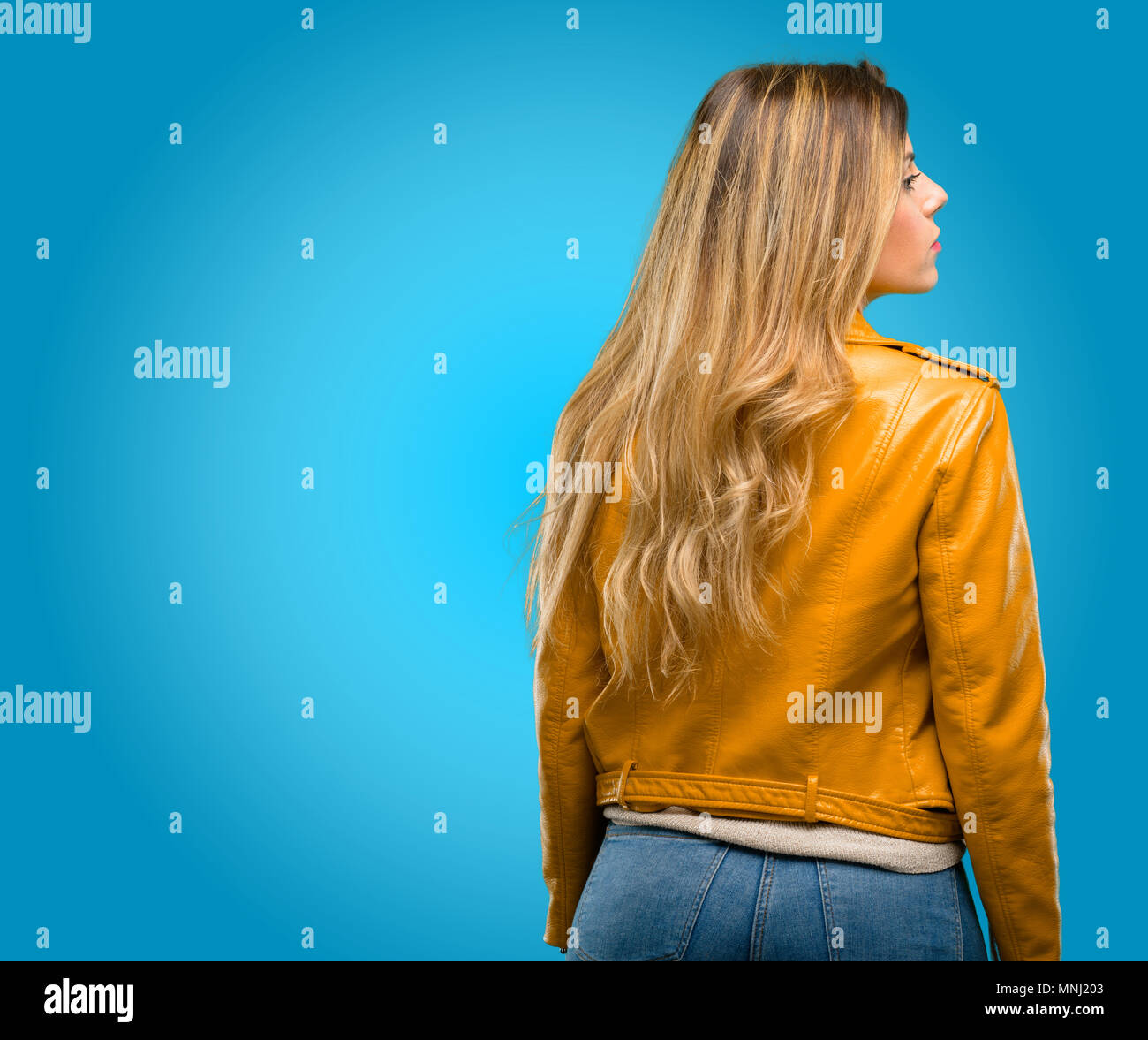 Beautiful young woman backside, rear view, blue background Stock Photo ...
