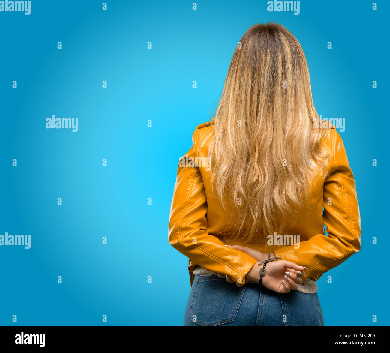 Beautiful young woman backside, rear view, blue background Stock Photo ...