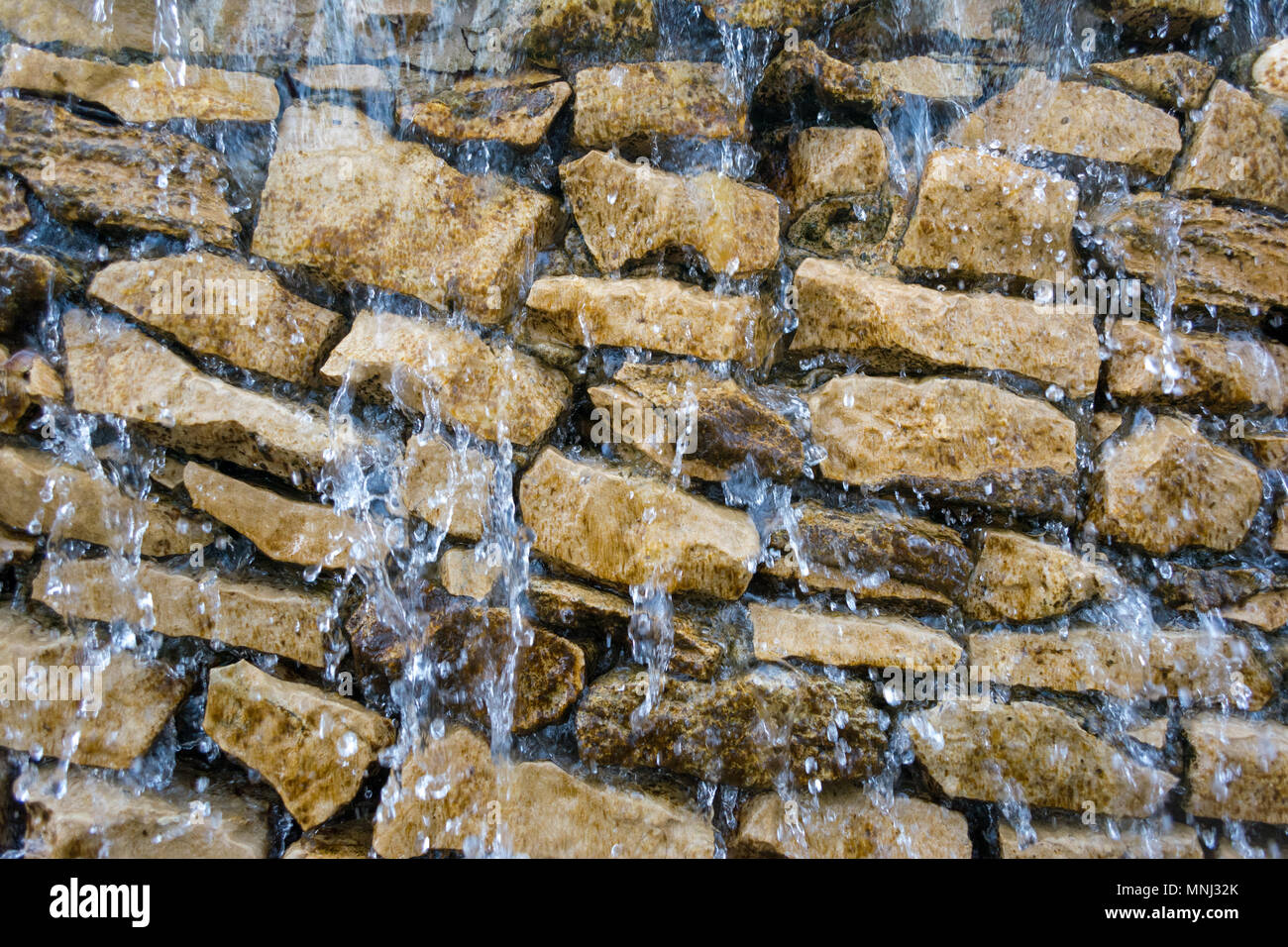 Waterfalls dripping and flowing down rock wall closeup Stock Photo - Alamy