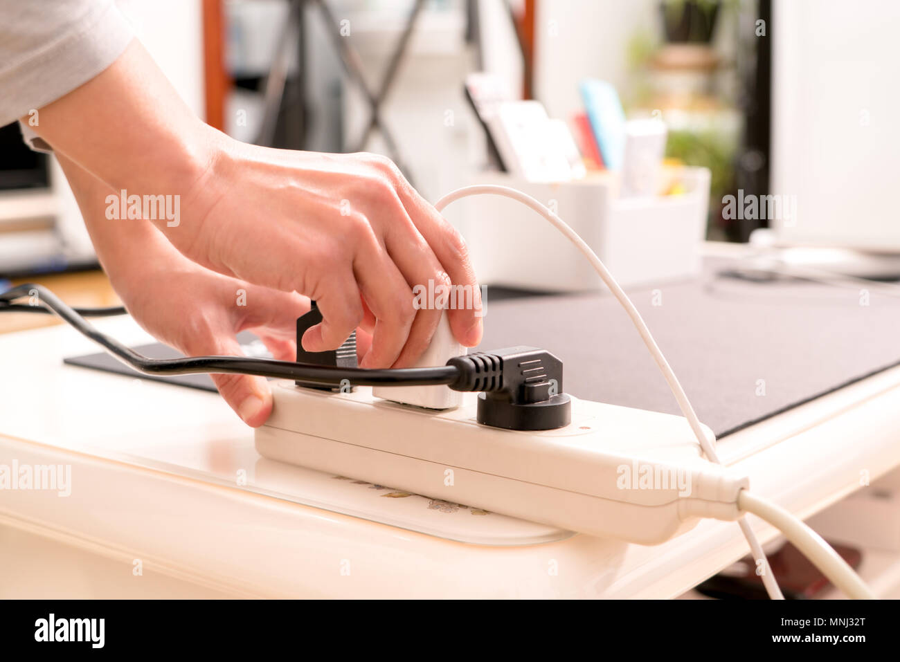 women hand putting the electric plug on the electricity supply ...