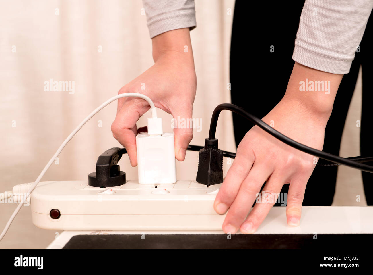 women hand putting the electric plug on the electricity supply ...
