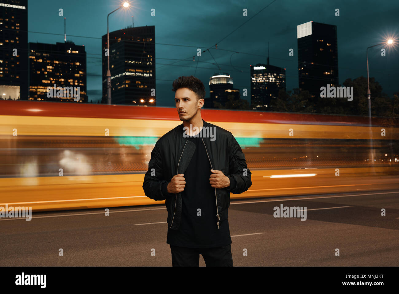 Portrait of stylish man on night city background pose to camera Stock ...