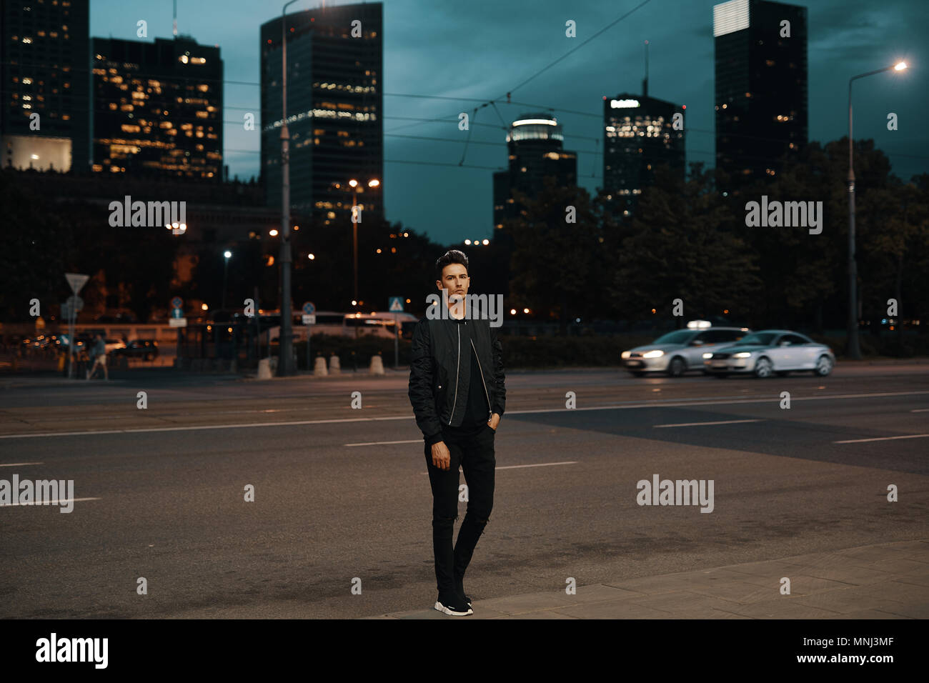 Portrait of stylish man on night city background pose to camera Stock ...