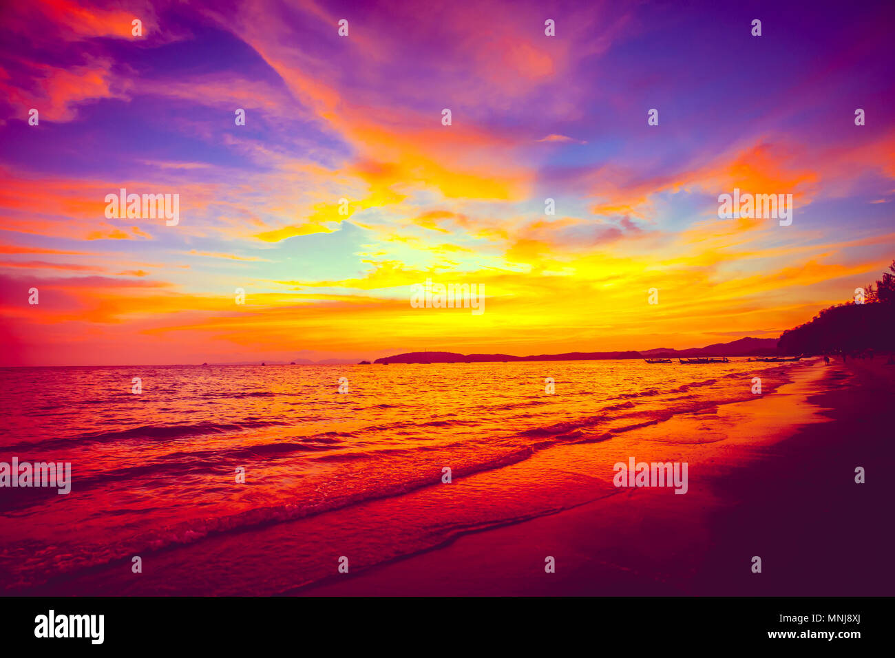 Amazing fairy tale colorful sunset over the calm ocean surface next to ...