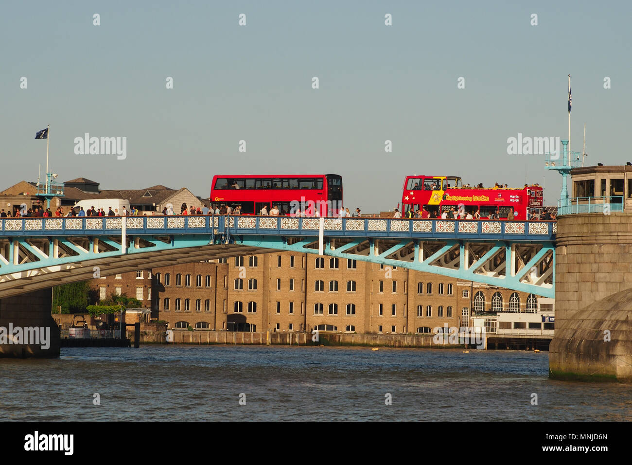 A view of two London buses, one open top, and pedestrians going over ...
