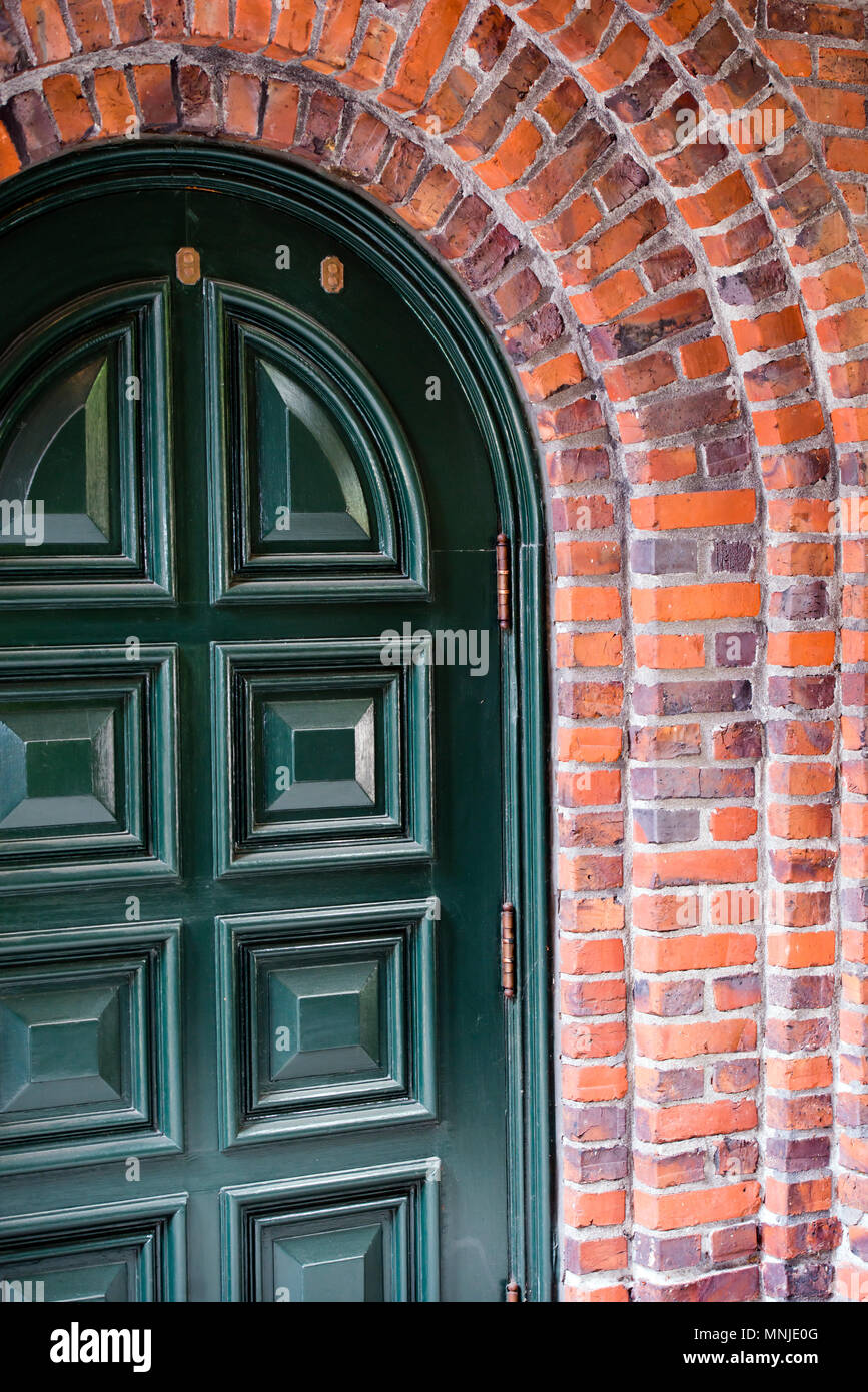 Old strong painted arched wood entrance door with convex panels ...