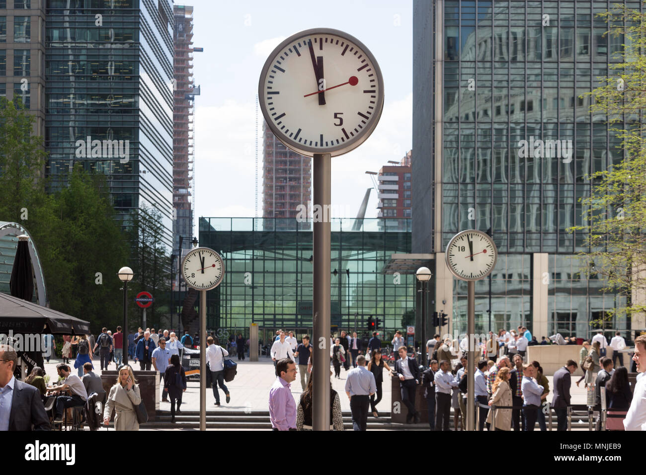 Canary Wharf, clocks show the time just before 12pm outside the ...