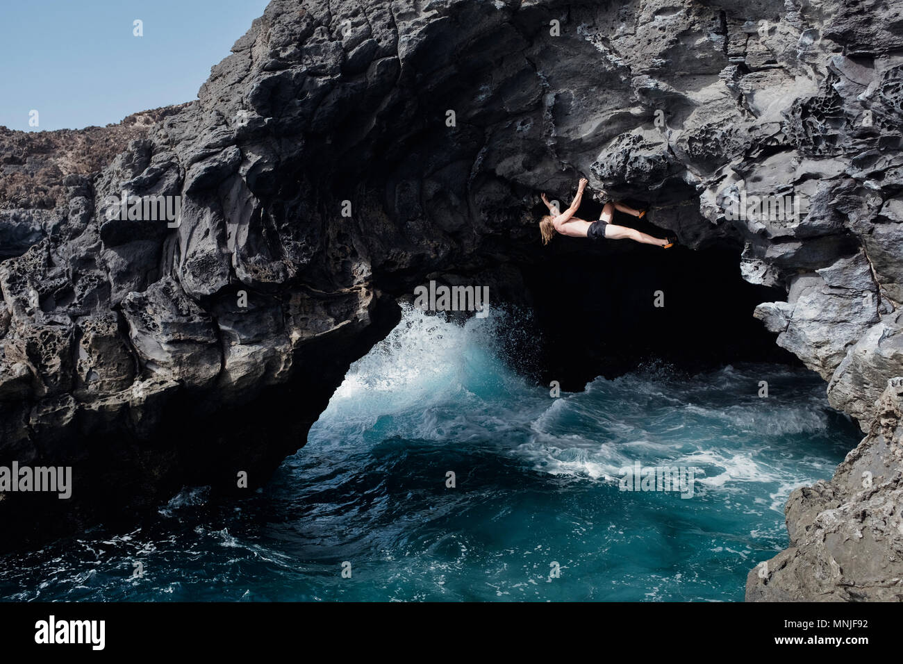 Man climbing coastal cave on sea shore hi-res stock photography and ...