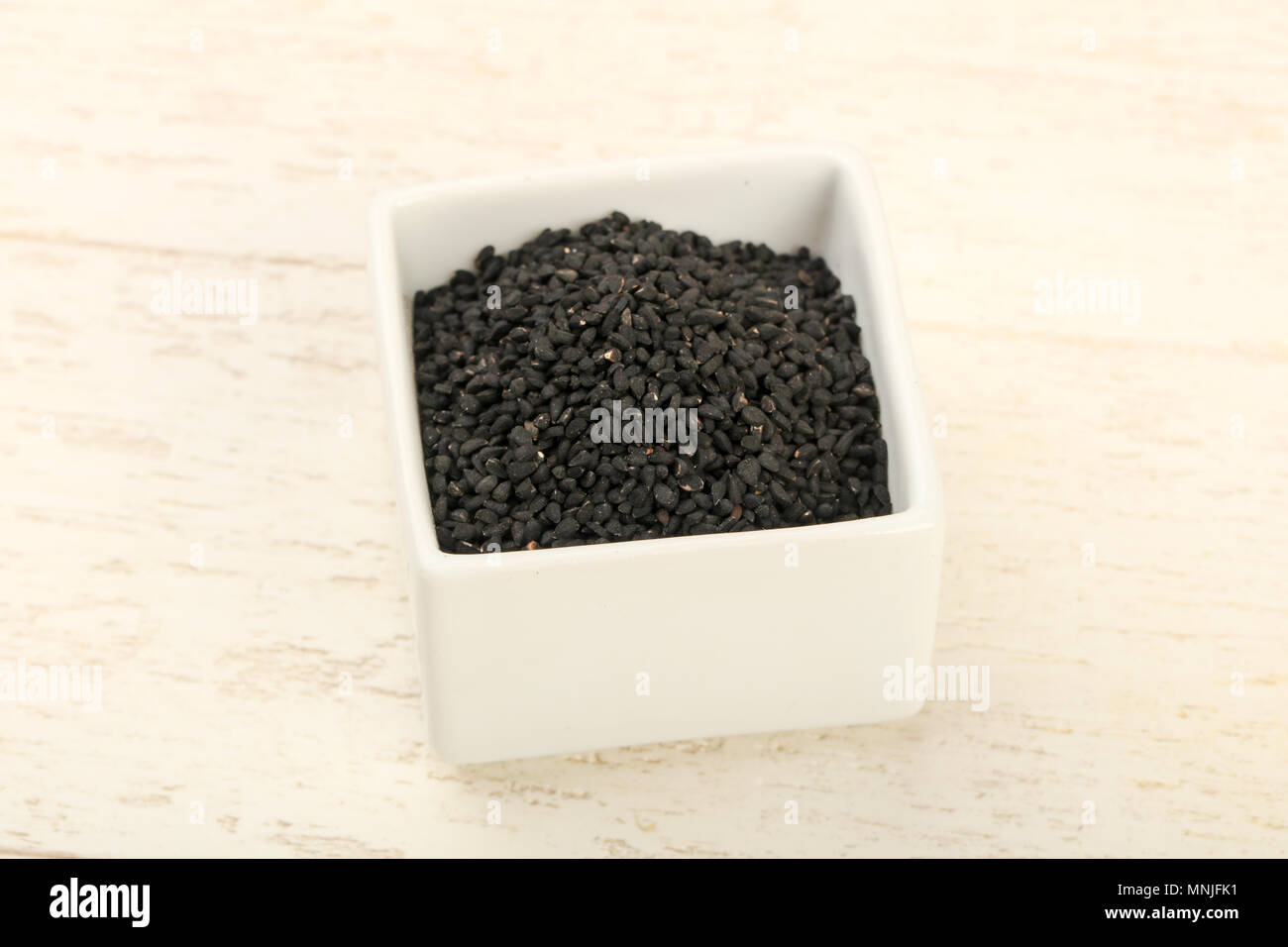 Black nigella seeds heap over wooden background Stock Photo - Alamy