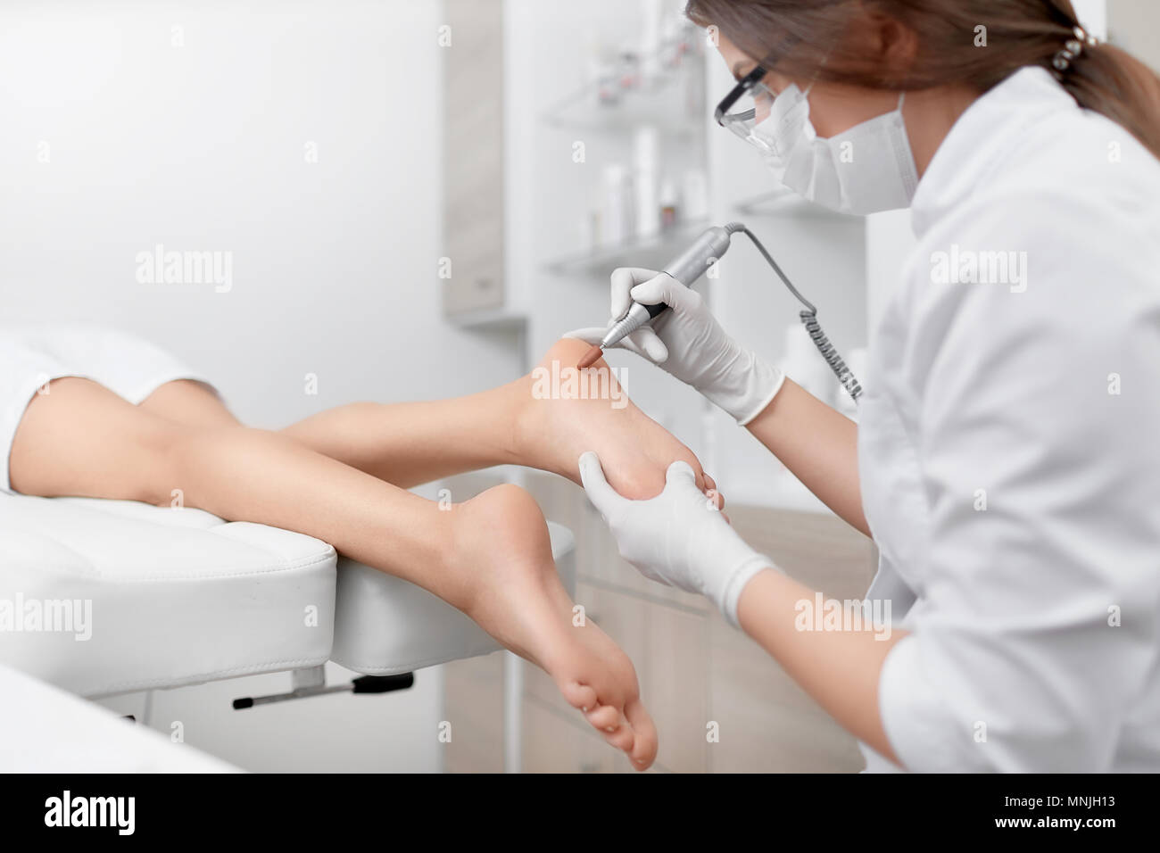 Podiatrist making procedure for client foot with special equipment ...