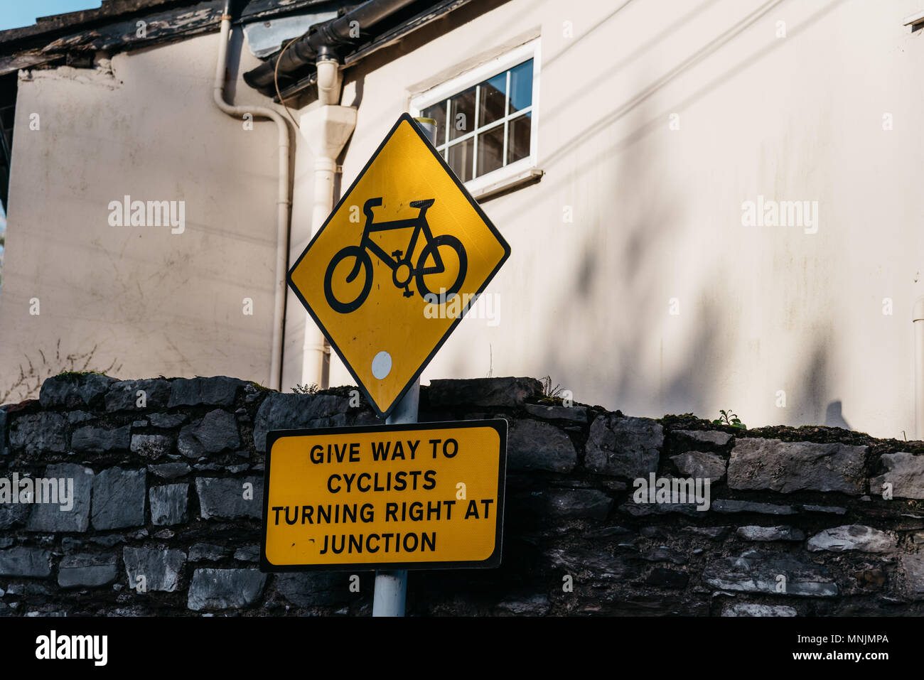 Yellow warning symbol in street of irish town Stock Photo - Alamy