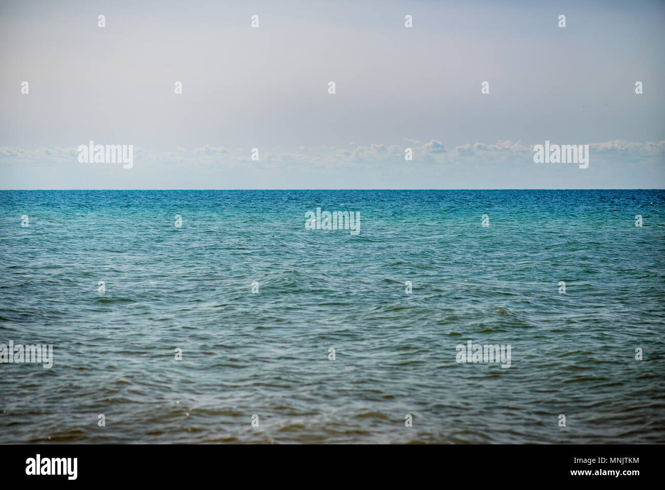 the blue ocean with dull clouds on a lovely sunny day Stock Photo - Alamy