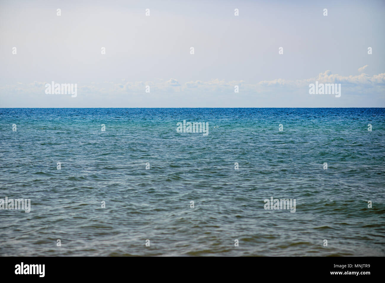 the blue ocean with dull clouds on a lovely sunny day Stock Photo - Alamy