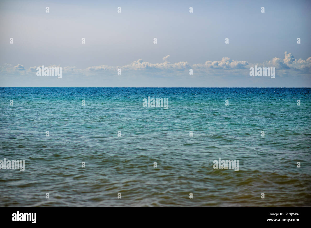 the blue ocean with dull clouds on a lovely sunny day Stock Photo - Alamy