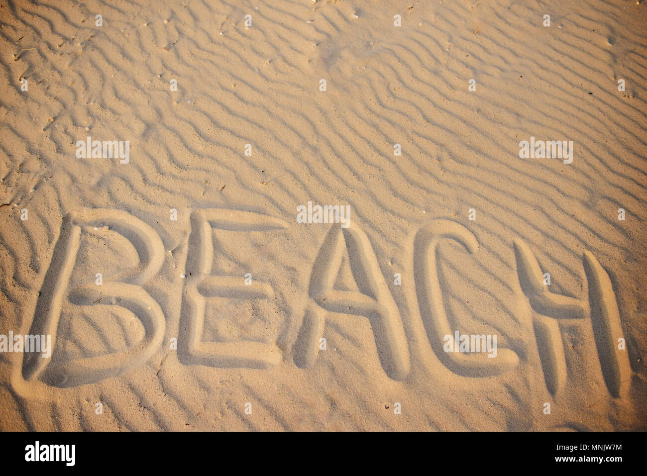 the word beach is written in the sand Stock Photo - Alamy