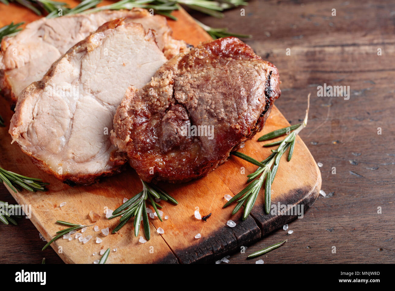Oven-baked pork with rosemary and spices on a old wooden table Stock ...