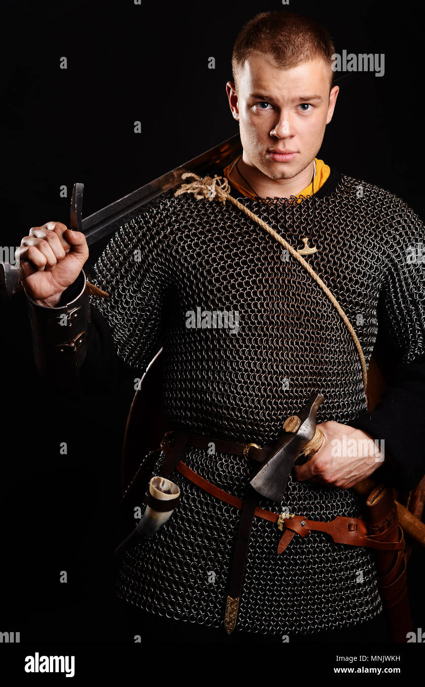 A soldier in a chain of letters stands with a sword in his hands on a ...