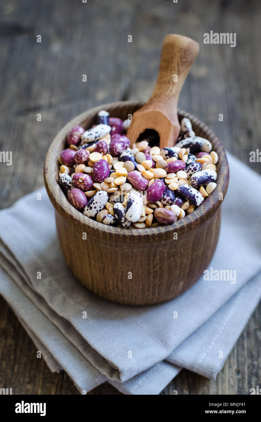 Assortment of dry organic beans and lentils in bowl on rustic wooden ...