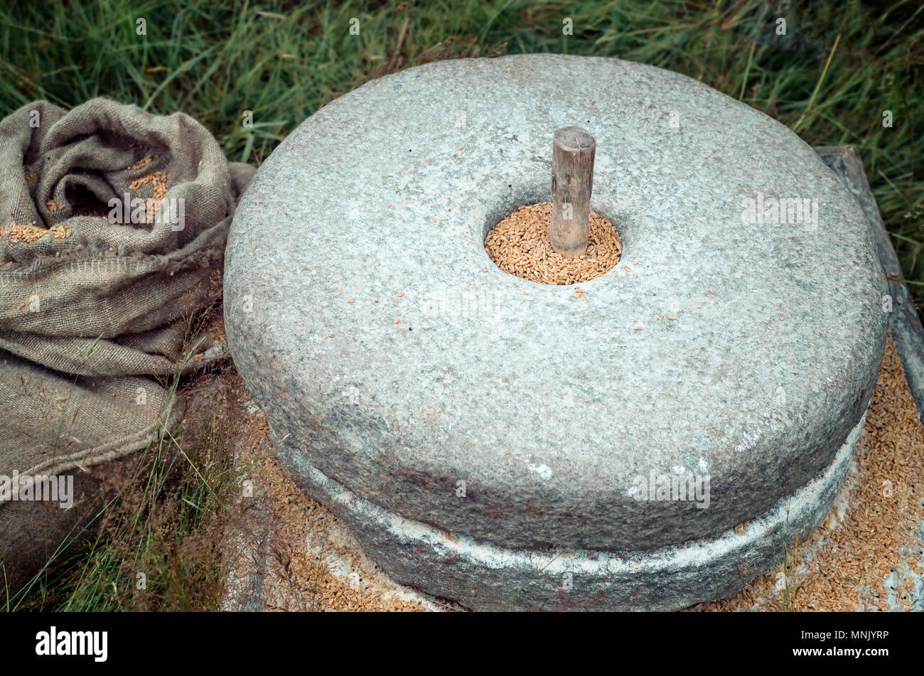 The ancient stone hand mill with grain and bag Stock Photo - Alamy