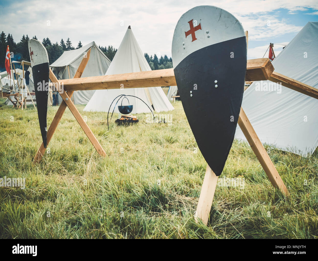 Outdoor scene of medieval way of life. Red black knights shield with ...