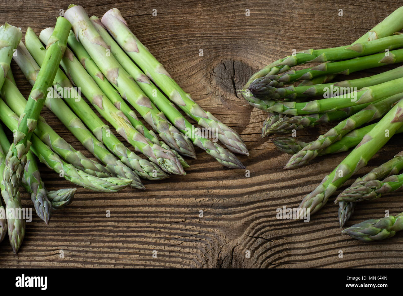 Raw garden asparagus stems. Fresh green spring vegetables on wooden ...
