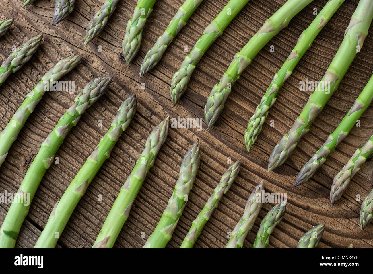 Raw garden asparagus stems. Fresh green spring vegetables on wooden ...