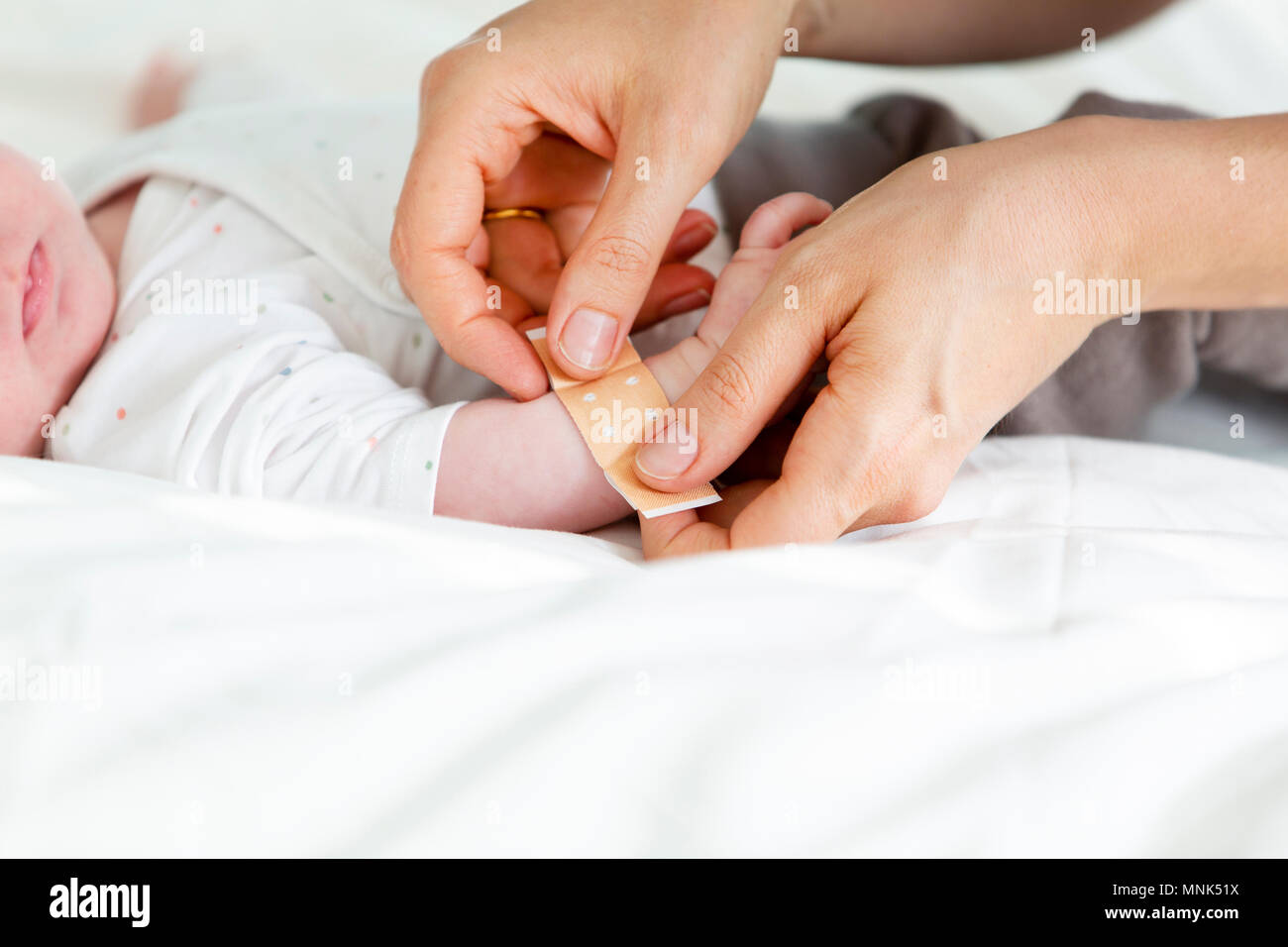 Mum putting plaster on child hi-res stock photography and images - Alamy