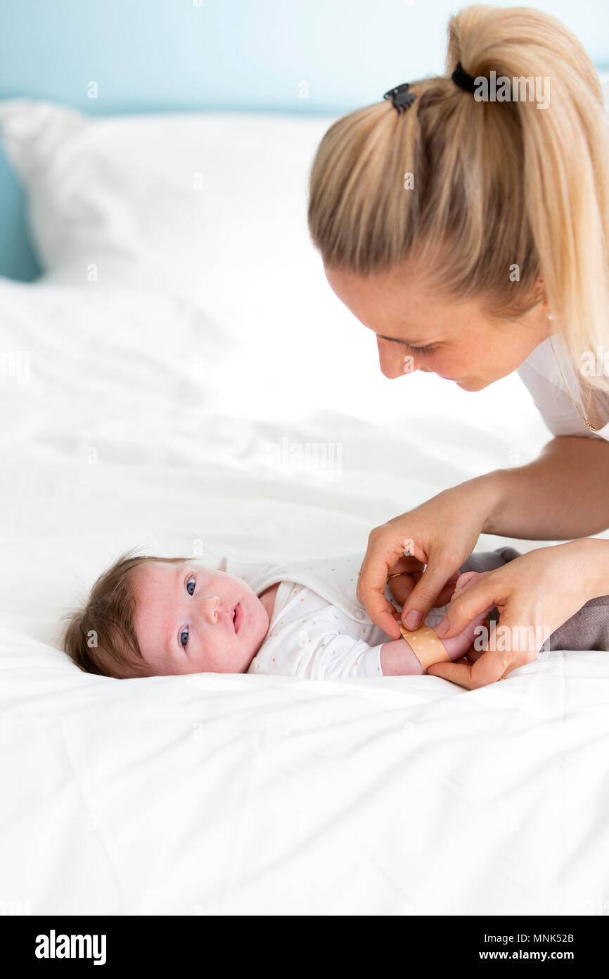 Mum putting plaster on child hi-res stock photography and images - Alamy