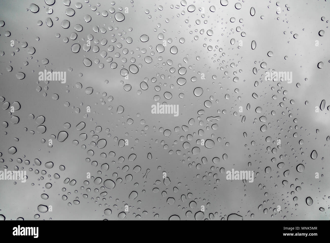 Rain drops on window glasses surface with cloudy background Stock Photo ...