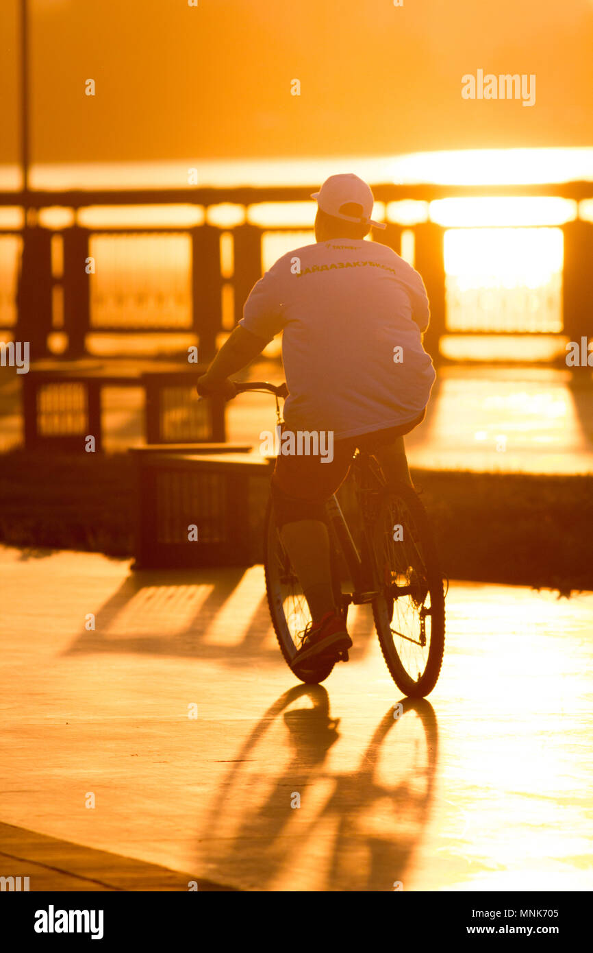 Silhouette of fat man cyclist riding on the promenade at sunset Stock ...