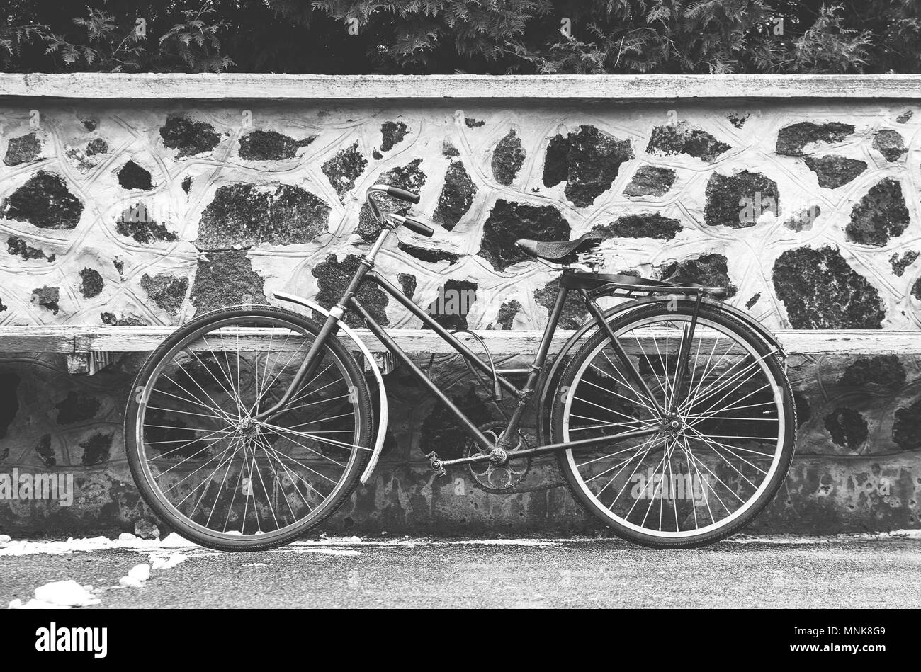 Vintage bicycle on the stone wall background. Afternoon in small ...