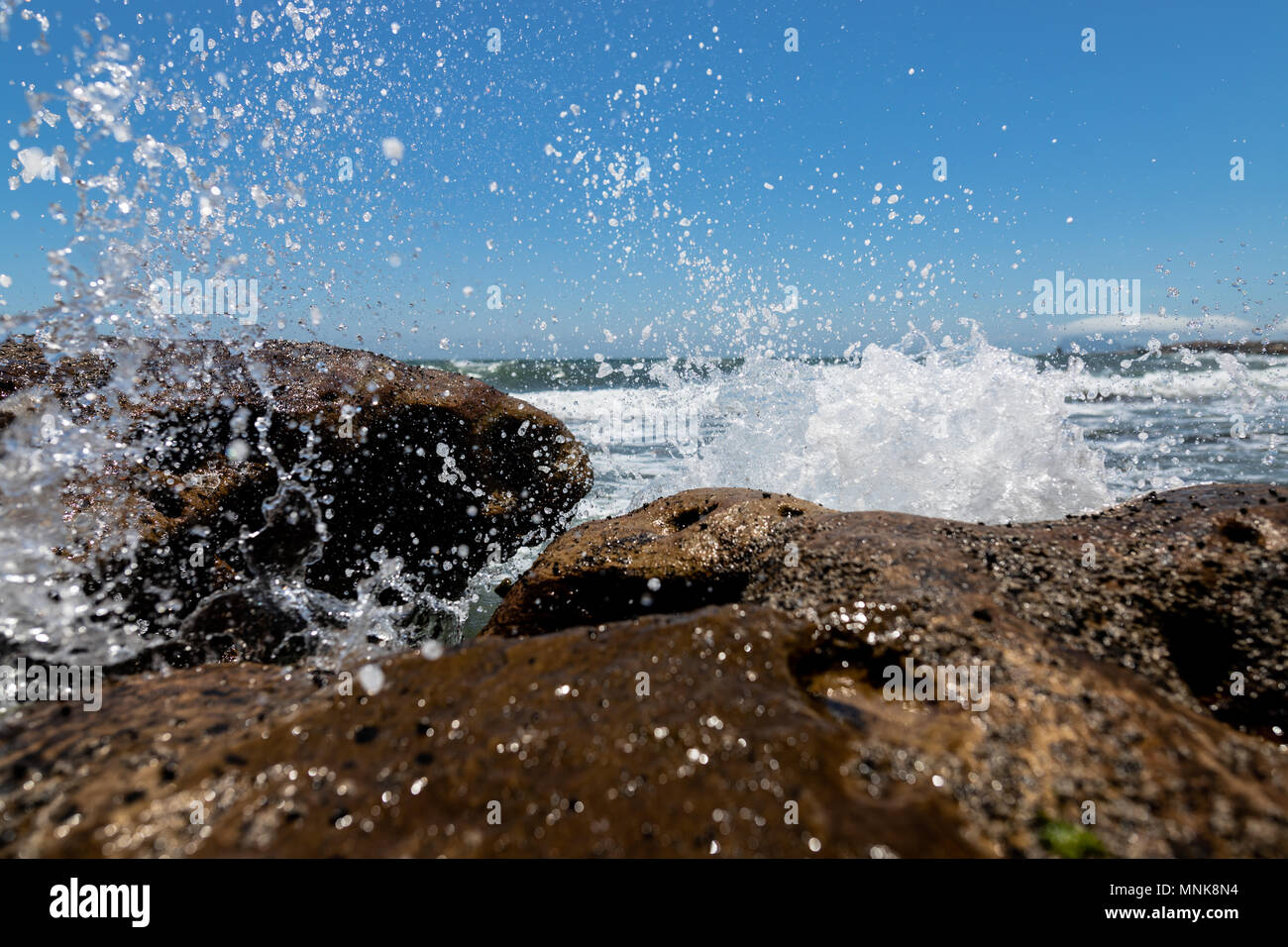 Water hitting rocks on a beach near Sotogrande on the Costa del Sol in ...