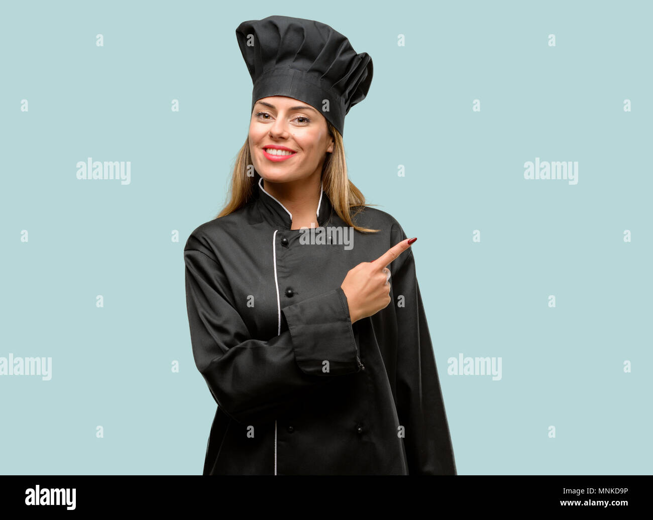 Young cook woman pointing away side with finger Stock Photo - Alamy