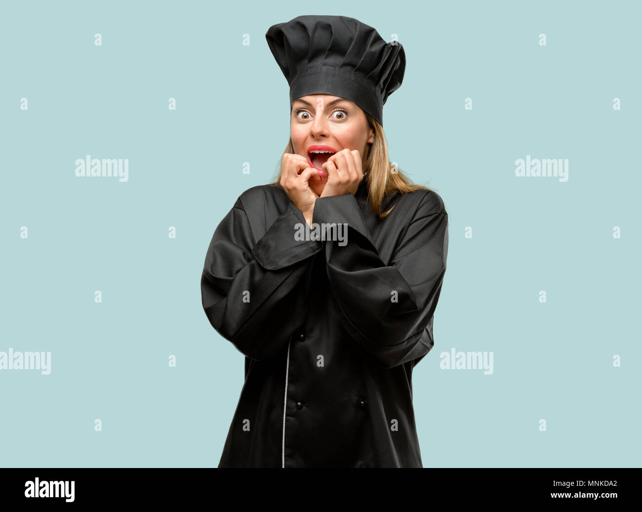 Young cook woman terrified and nervous expressing anxiety and panic ...