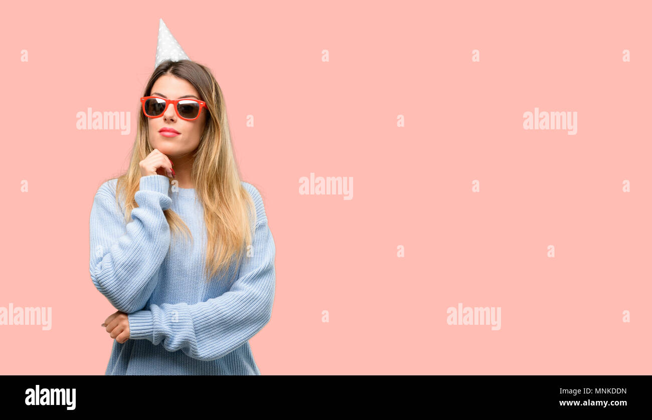 Young woman celebrates birthday thinking and looking up expressing ...