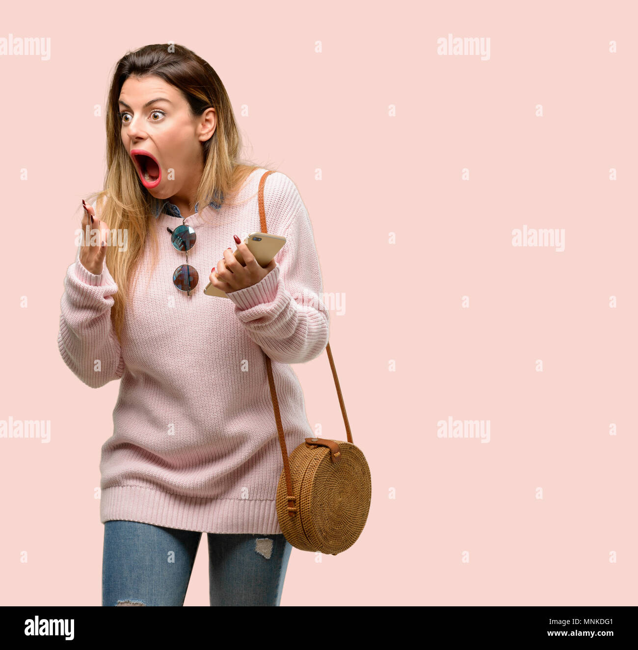 Young trendy woman stressful keeping hands on head, terrified in panic ...