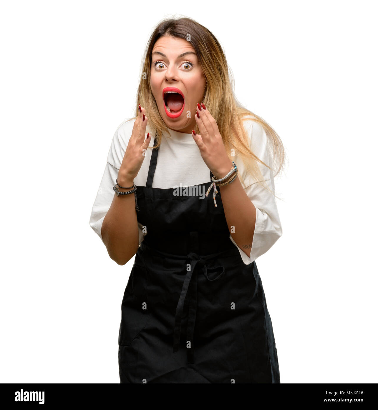 Shop owner woman wearing apron stressful keeping hands on head ...