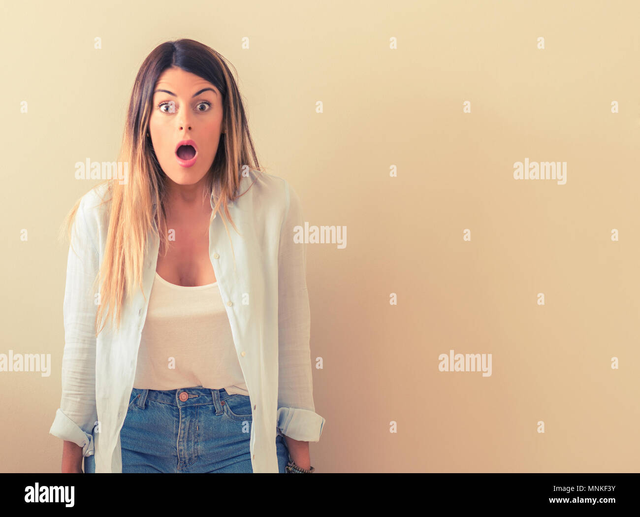 Vintage photo of a Beautiful woman against wall scared in shock ...