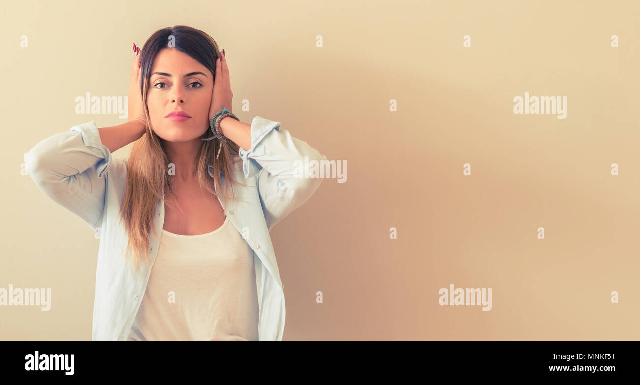 Vintage photo of a Beautiful woman against wall covering ears ignoring ...