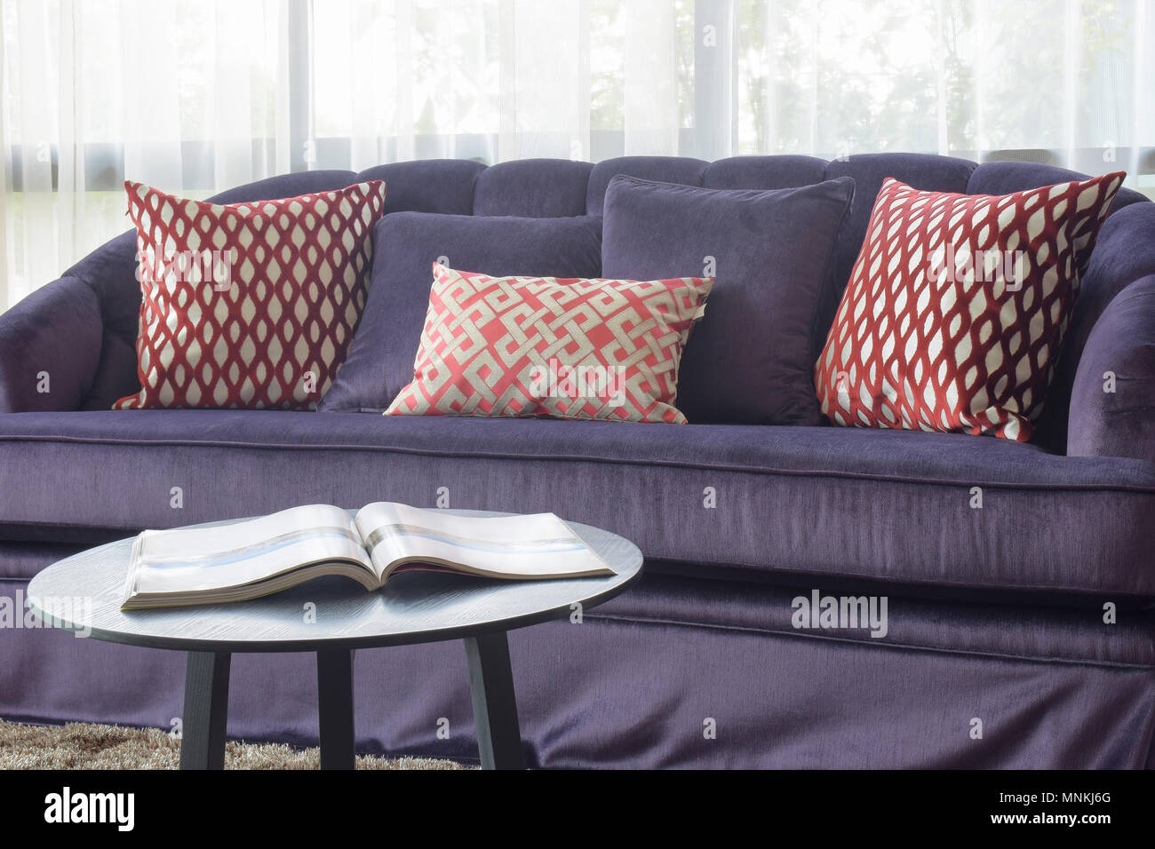Magazine on table with violet sofa set in background Stock Photo - Alamy