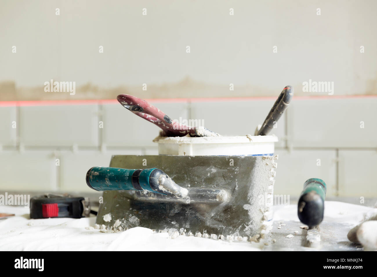 Process of tiling the tiles in the kitchen with necessary tiling tools ...