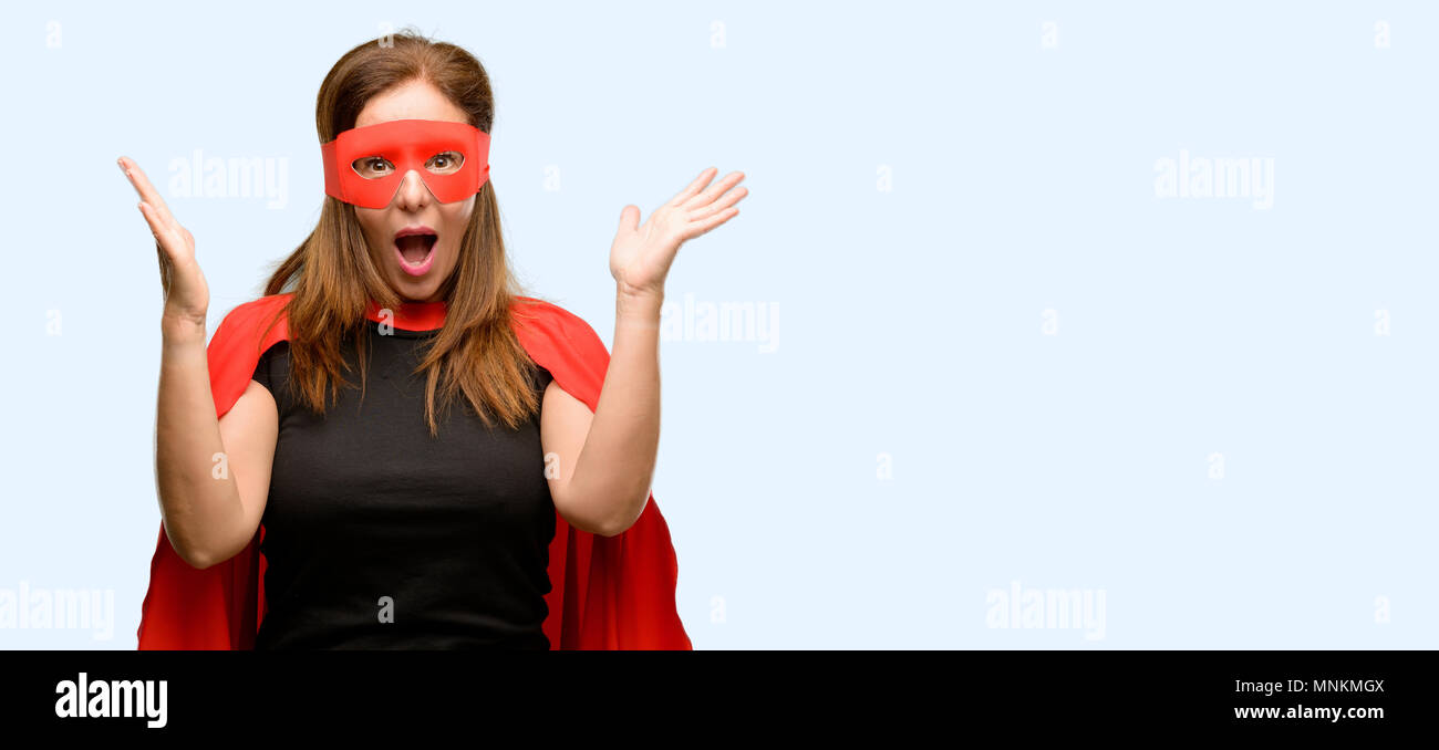 Middle age super hero woman wearing red mask and cape happy and ...